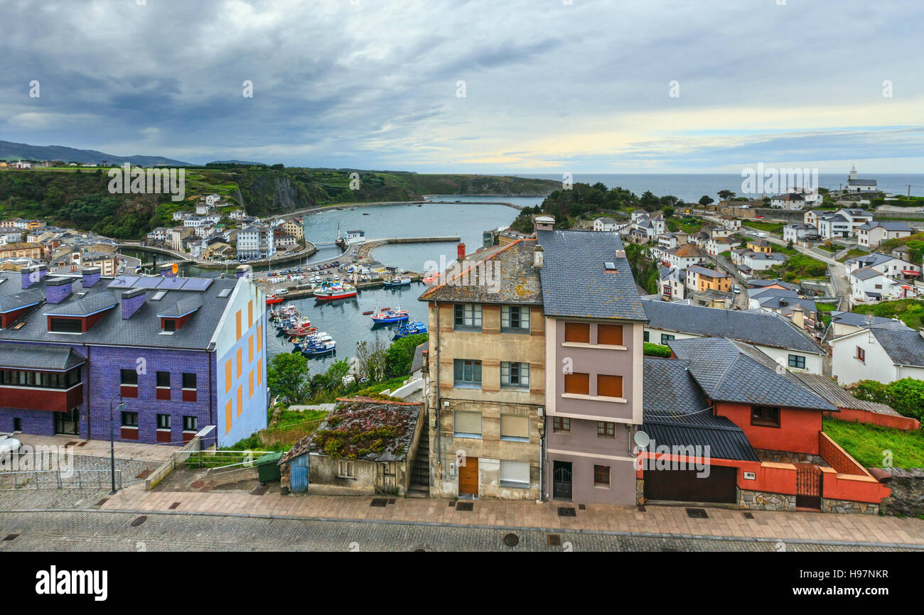 Evening Luarca cityscape (top view) with colorful boats in fishing port ...