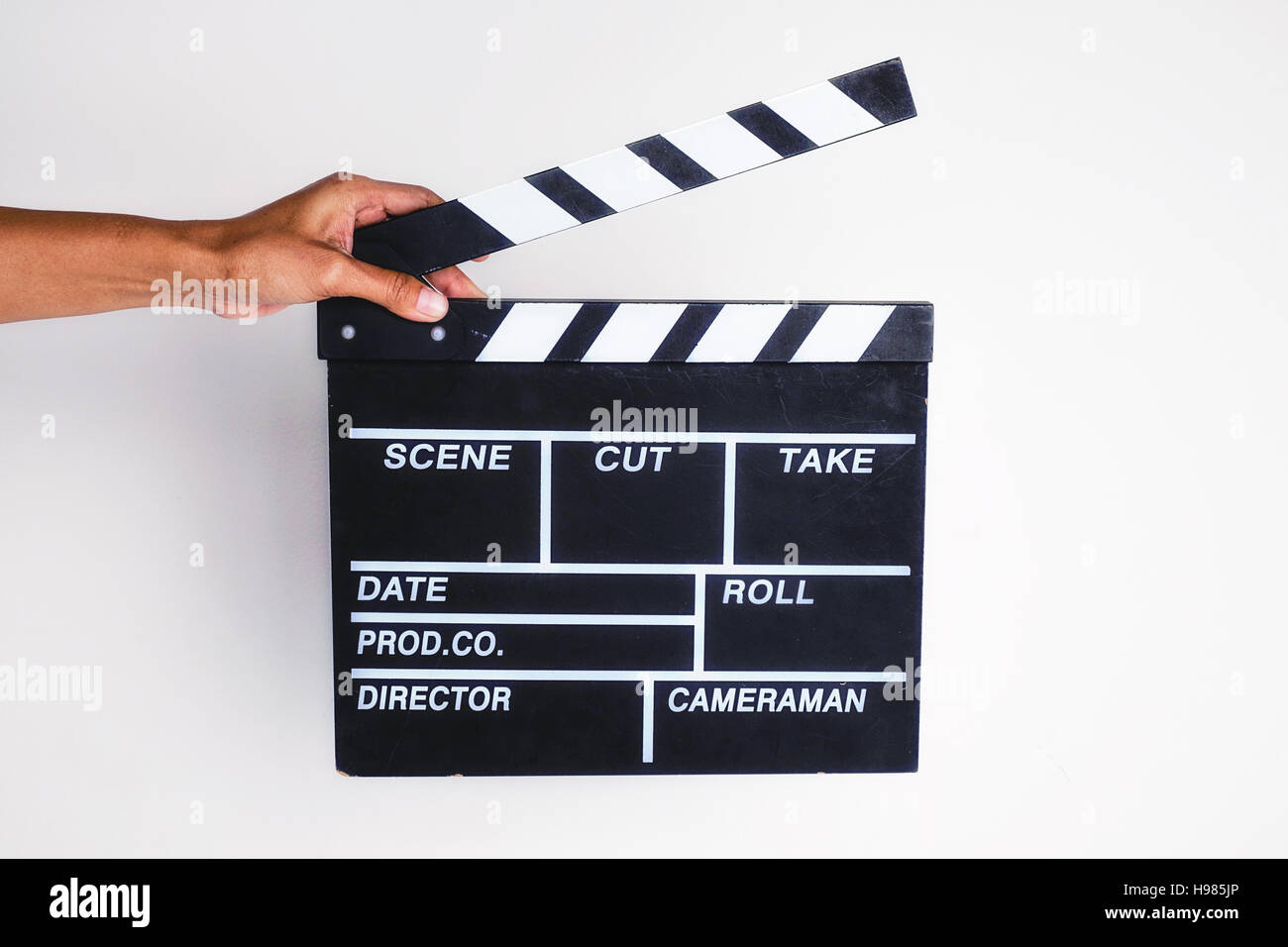 closeup of a young man about to clap a traditional wooden clapperboard ...