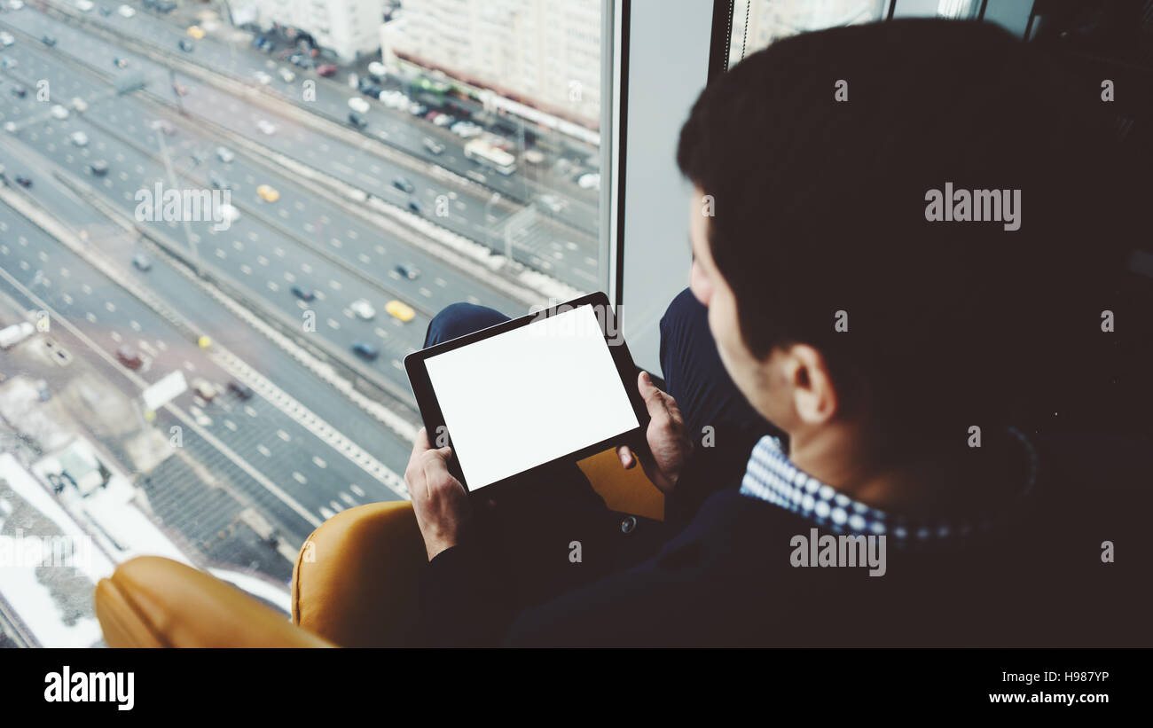 Mock up template of tablet pc in hands of businessman sitting near ...