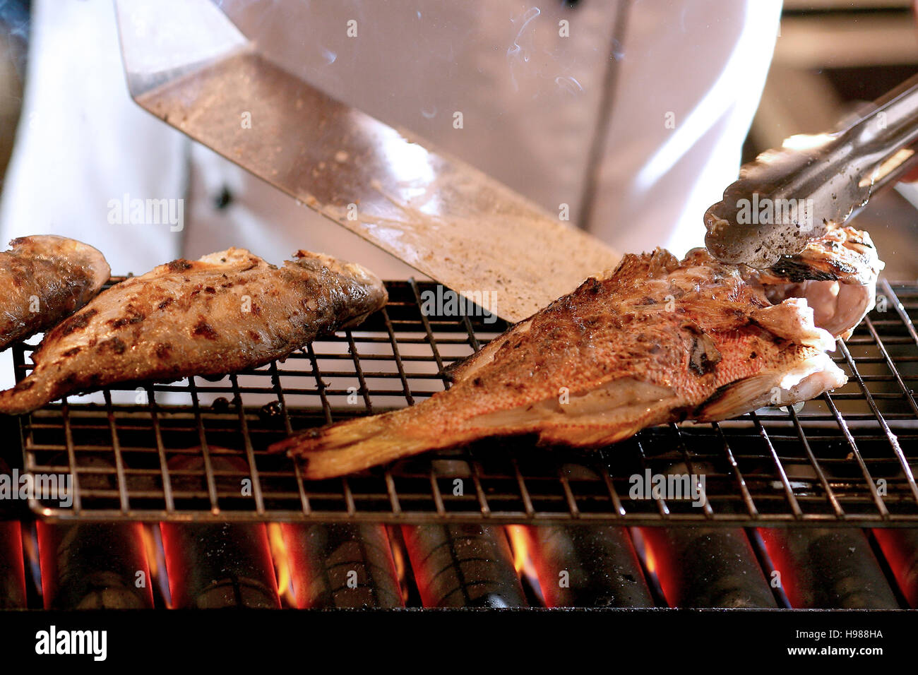 Grilled fish on the flaming grill by chef Stock Photo - Alamy