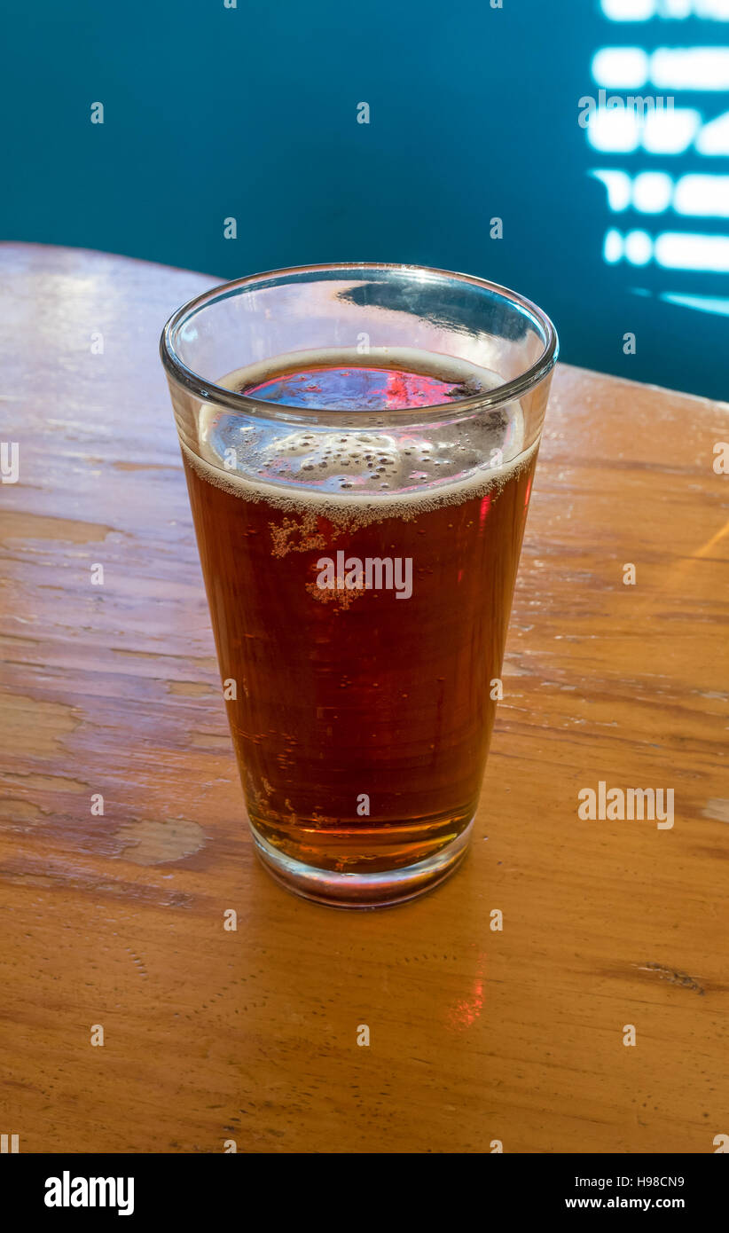 Amber beer in a glass with color refections Stock Photo - Alamy
