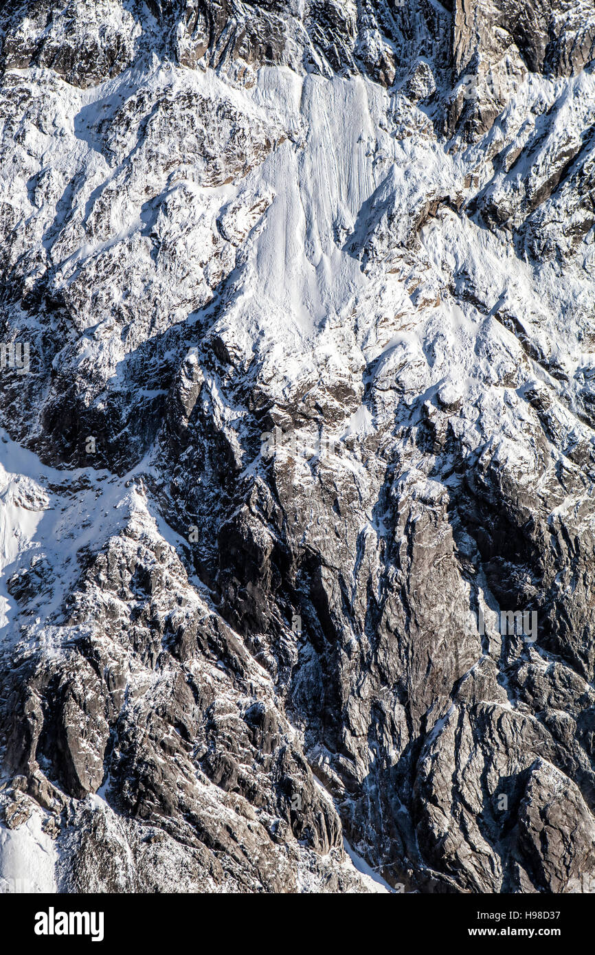 Cliff face in the Alaskan range mountains with rock and a light dusting ...