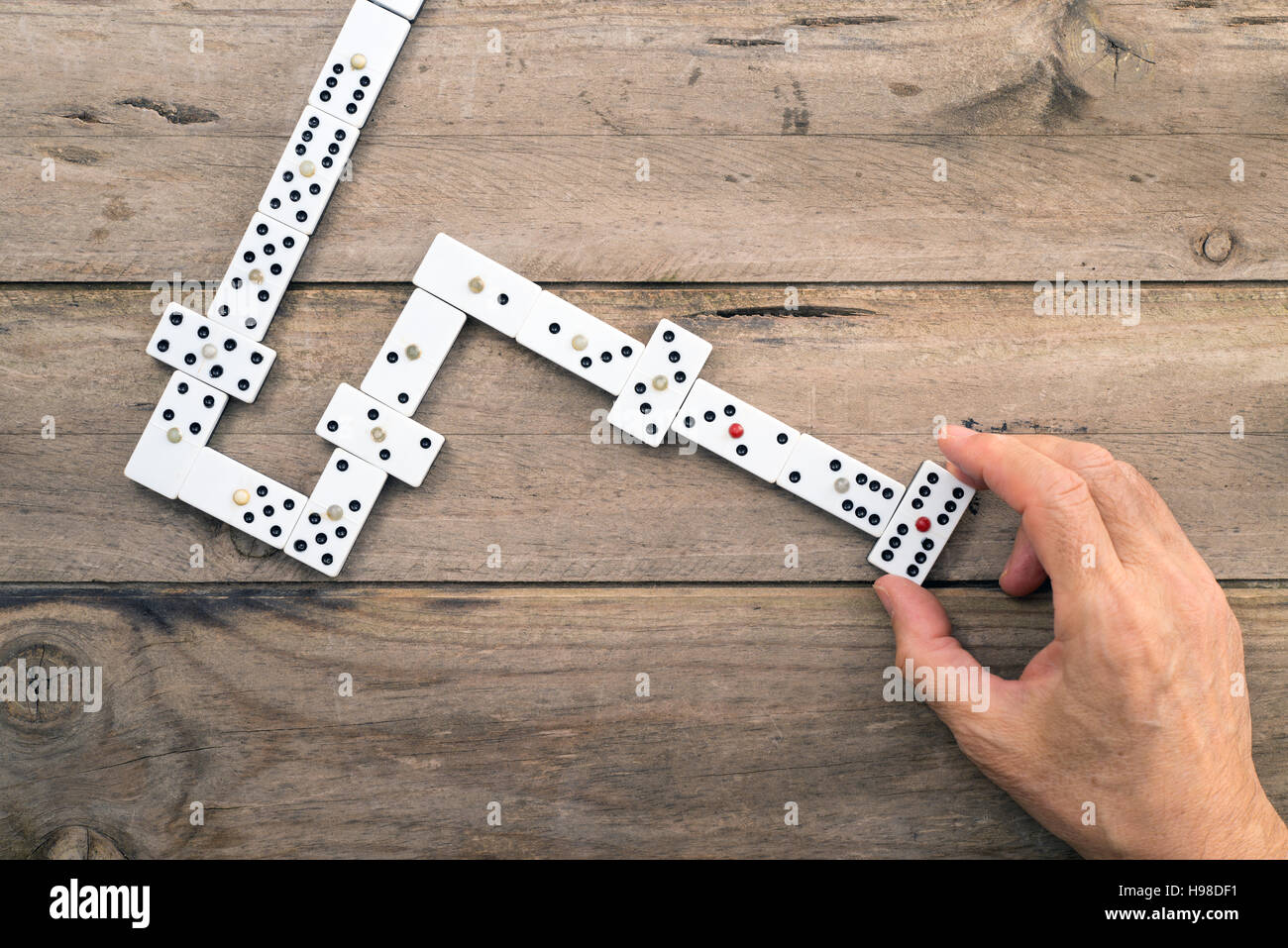 Man's hand placing a domino token Stock Photo - Alamy