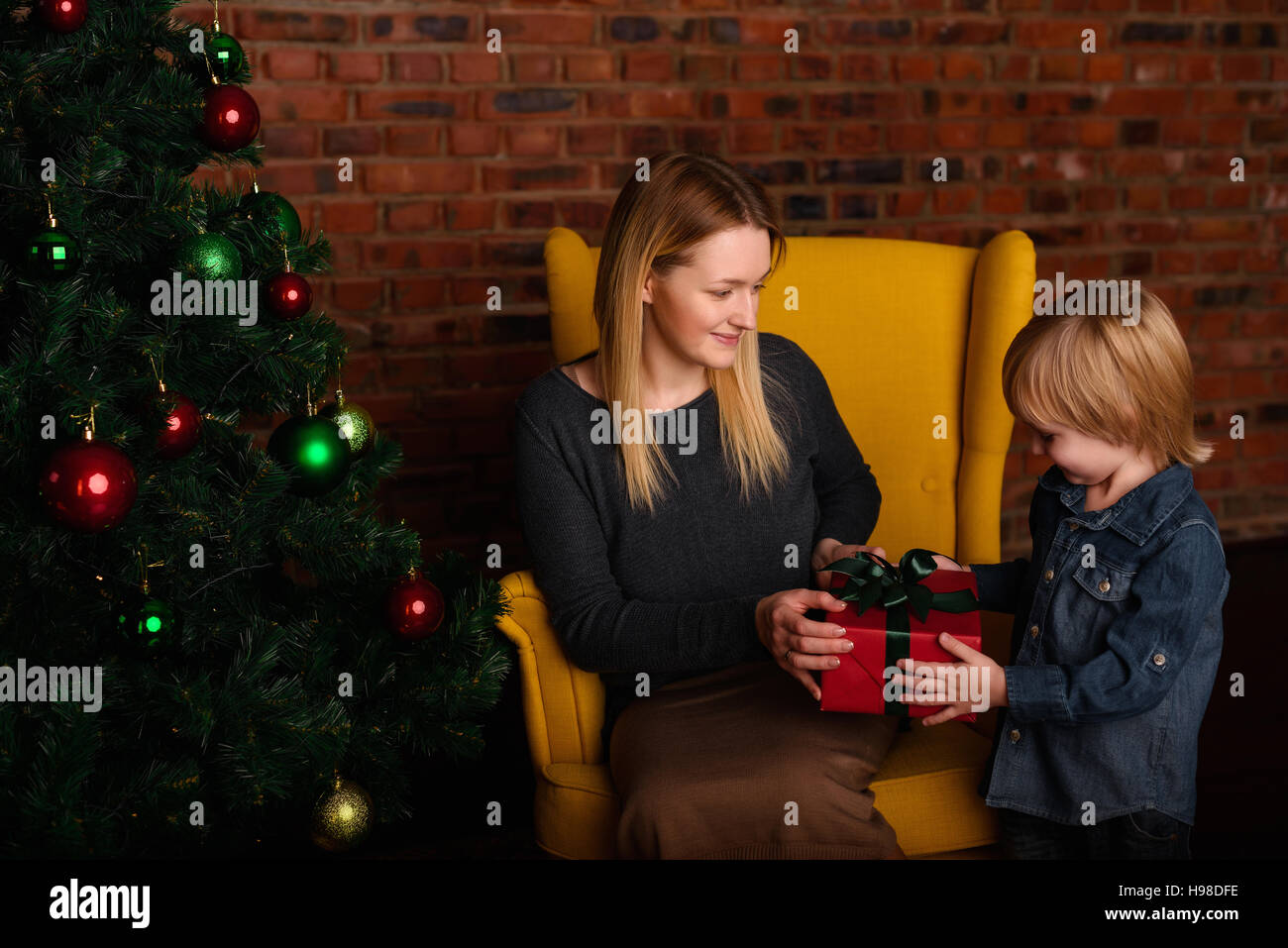 Mom gives a child Christmas gift Stock Photo - Alamy