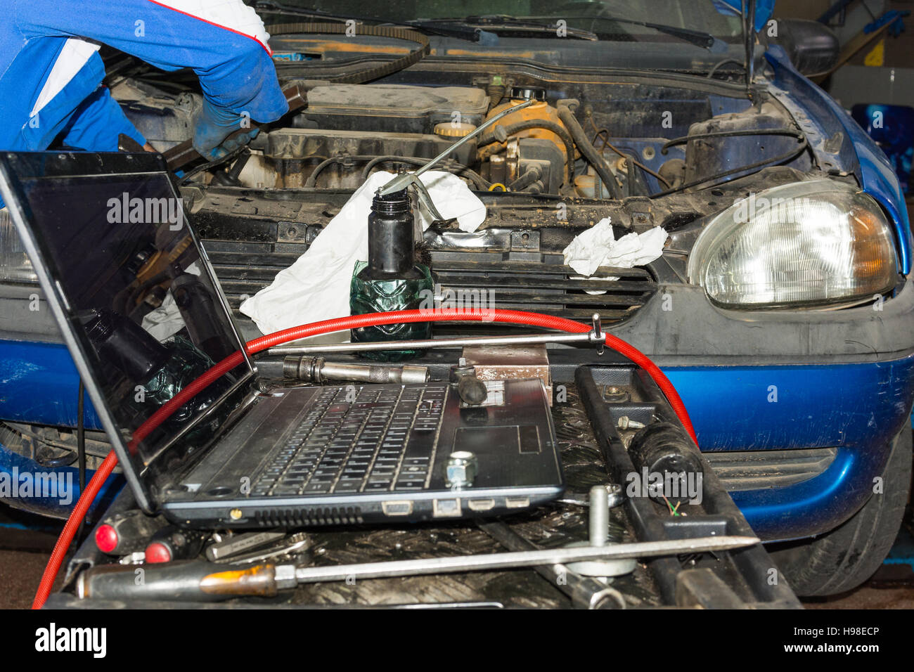 Car mechanic fixing an engine in his garage. copy space Stock Photo - Alamy
