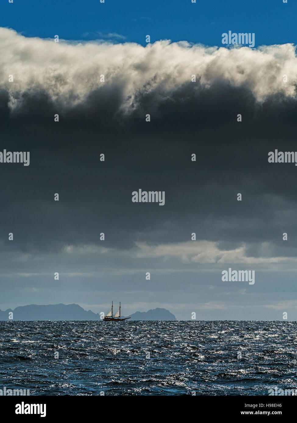 Deserted Islands: a two-masted boat sails past Ilhas Desertas, a small ...