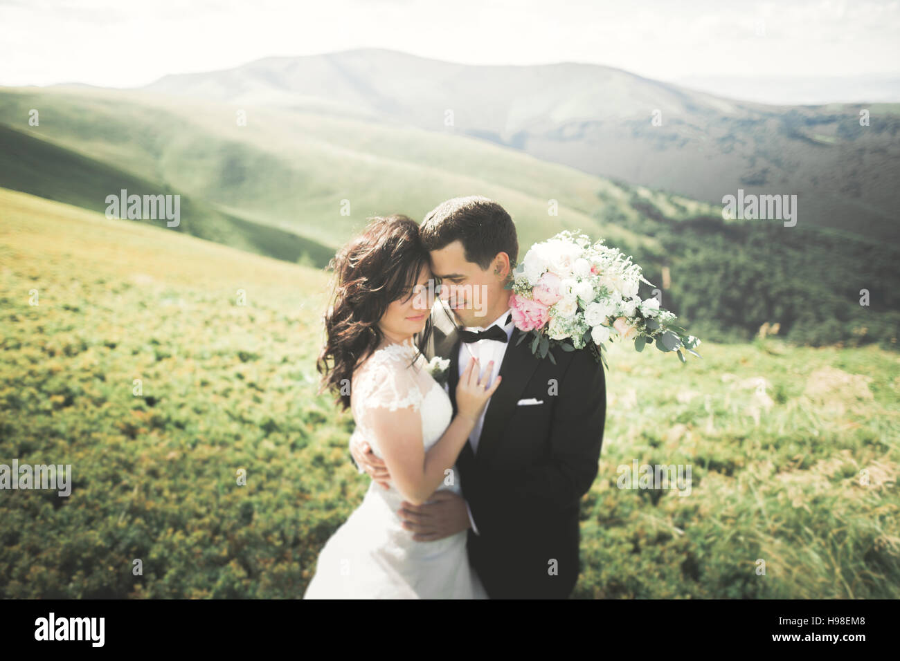 Beautiful fabulous happy bride and stylish groom posing on the ...