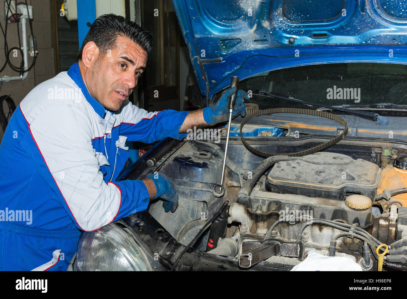 Car mechanic fixing an engine in his garage. copy space Stock Photo - Alamy