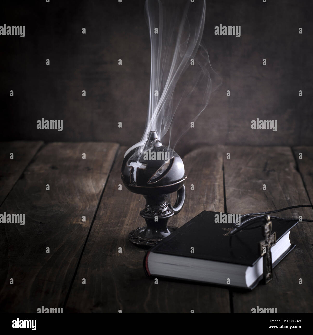 Smoking thurible burning frankincense and bible on table Stock Photo ...