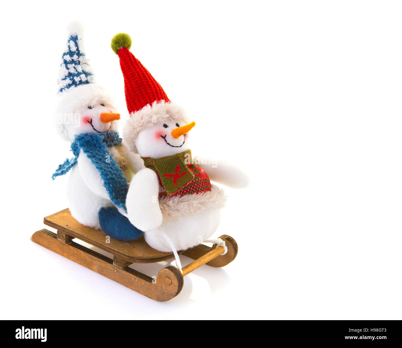 Two Snowmen on a sledge on a white background Stock Photo - Alamy