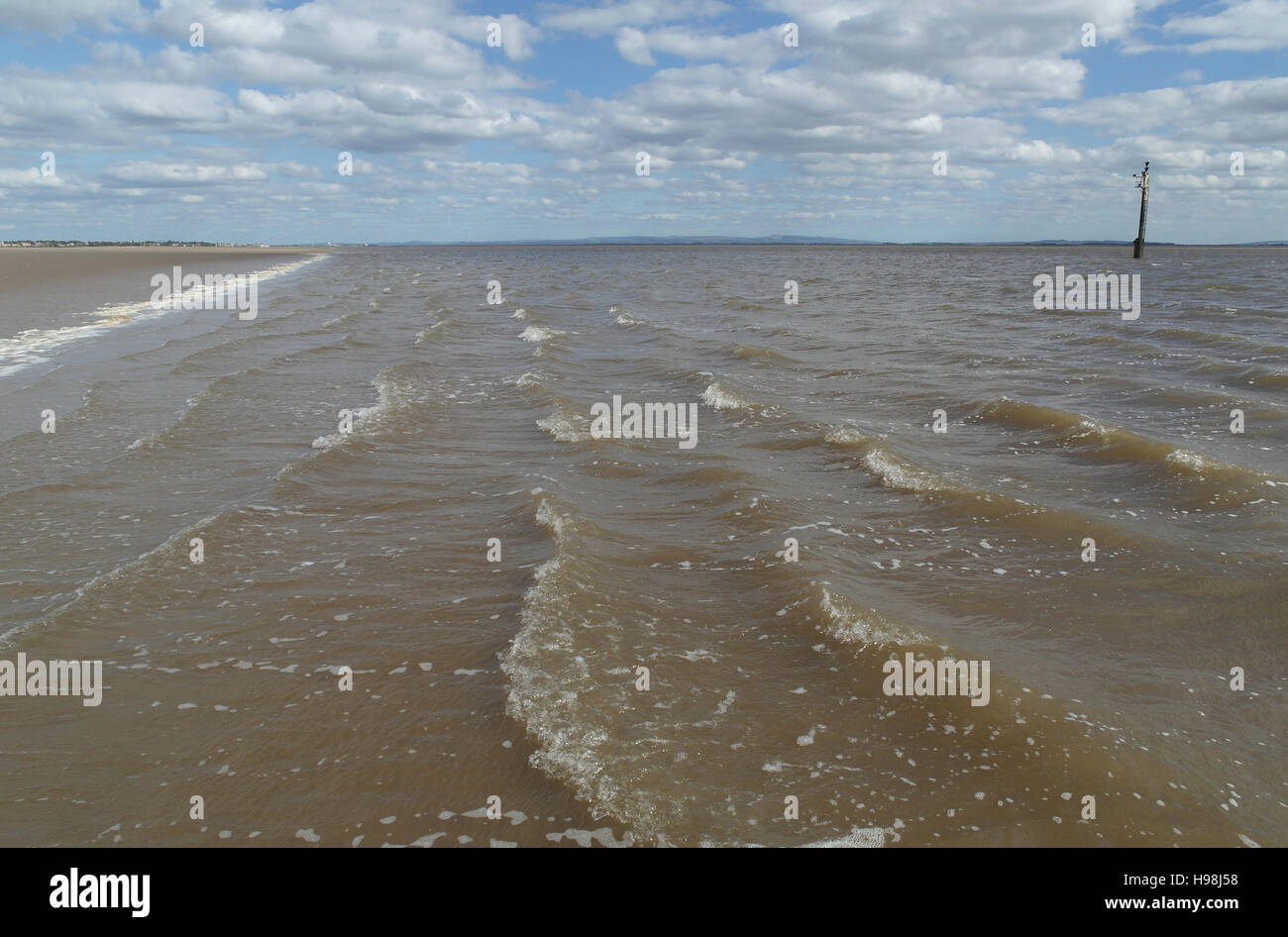 Rising tide with small waves and sand beach sea foam, River Ribble ...