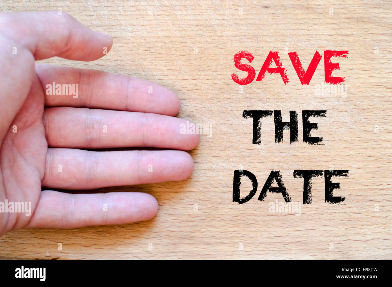Human hand over wooden background and save the date text concept Stock ...