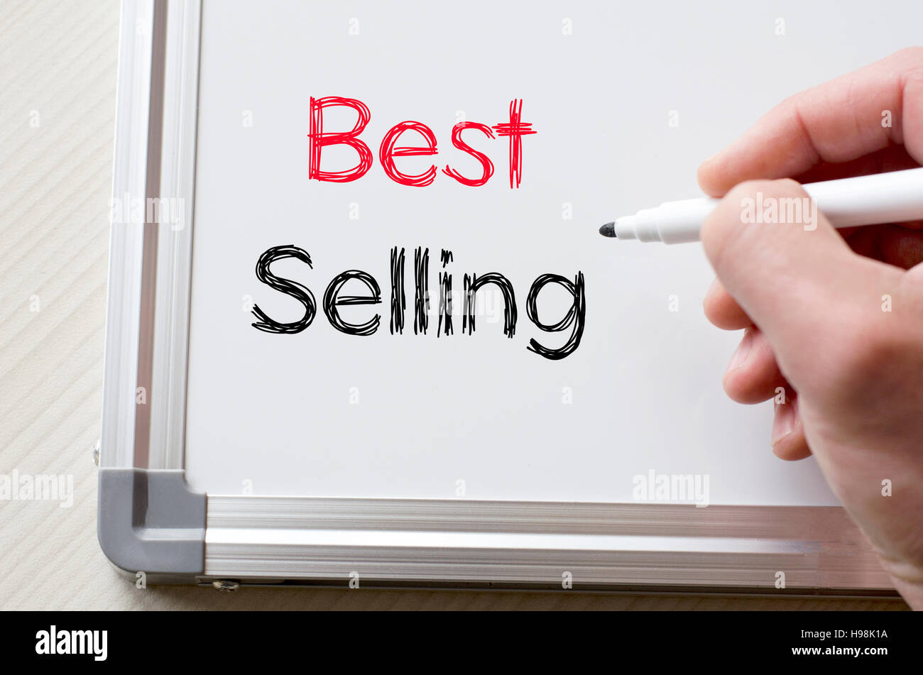 Human hand writing best selling on whiteboard Stock Photo - Alamy