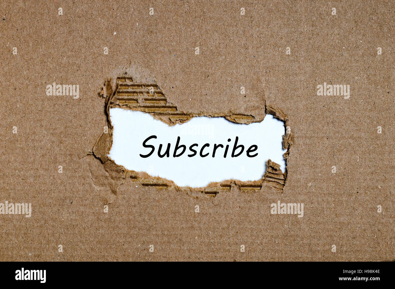 The word subscribe appearing behind torn paper Stock Photo - Alamy