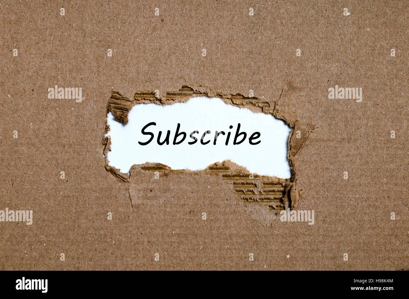 The word subscribe appearing behind torn paper Stock Photo - Alamy