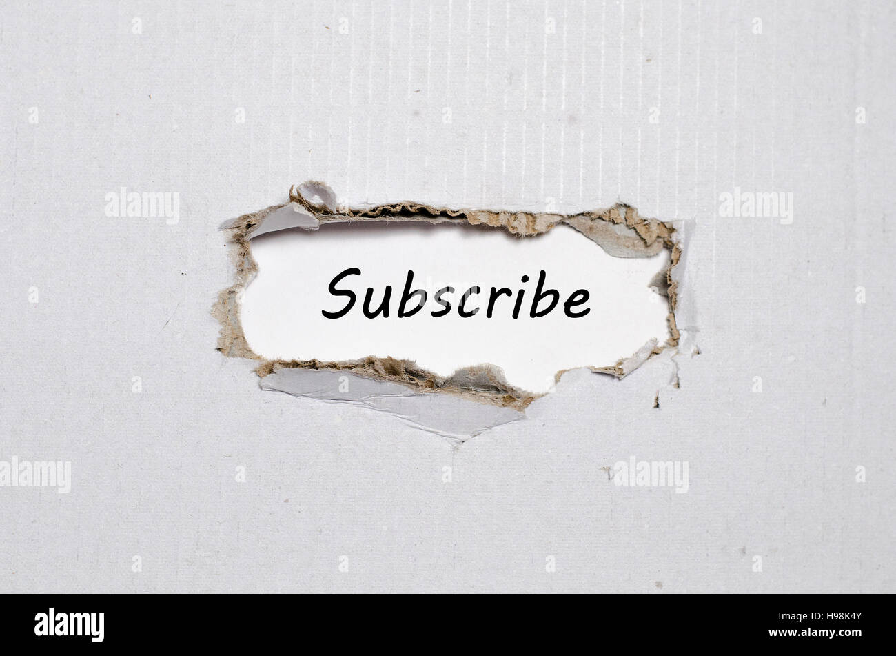 The word subscribe appearing behind torn paper Stock Photo - Alamy