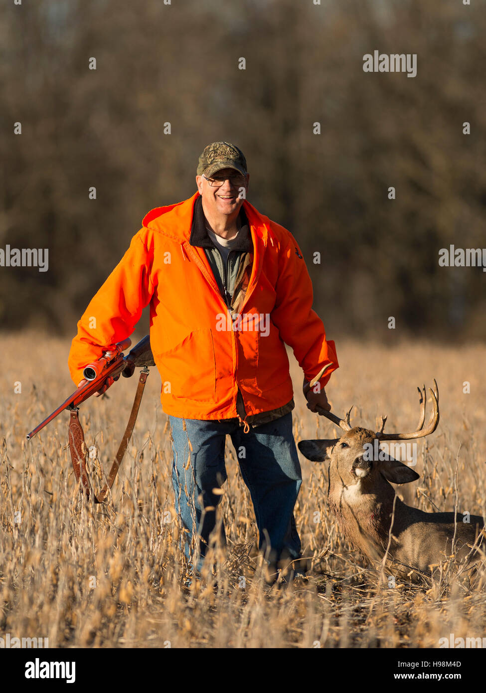 A deer hunter with a large Whitetail Buck Stock Photo - Alamy
