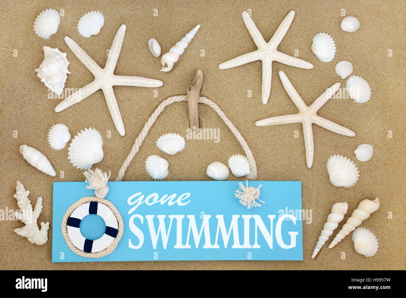 Gone swimming sign on sand with starfish and seashells forming an ...