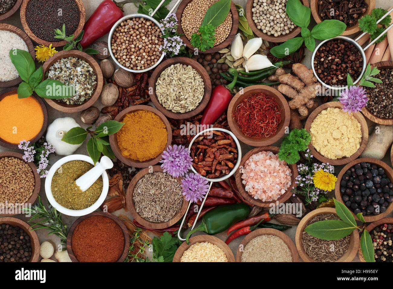 Herb and spice seasoning in wooden bowls, scoops and mortar with pestle ...