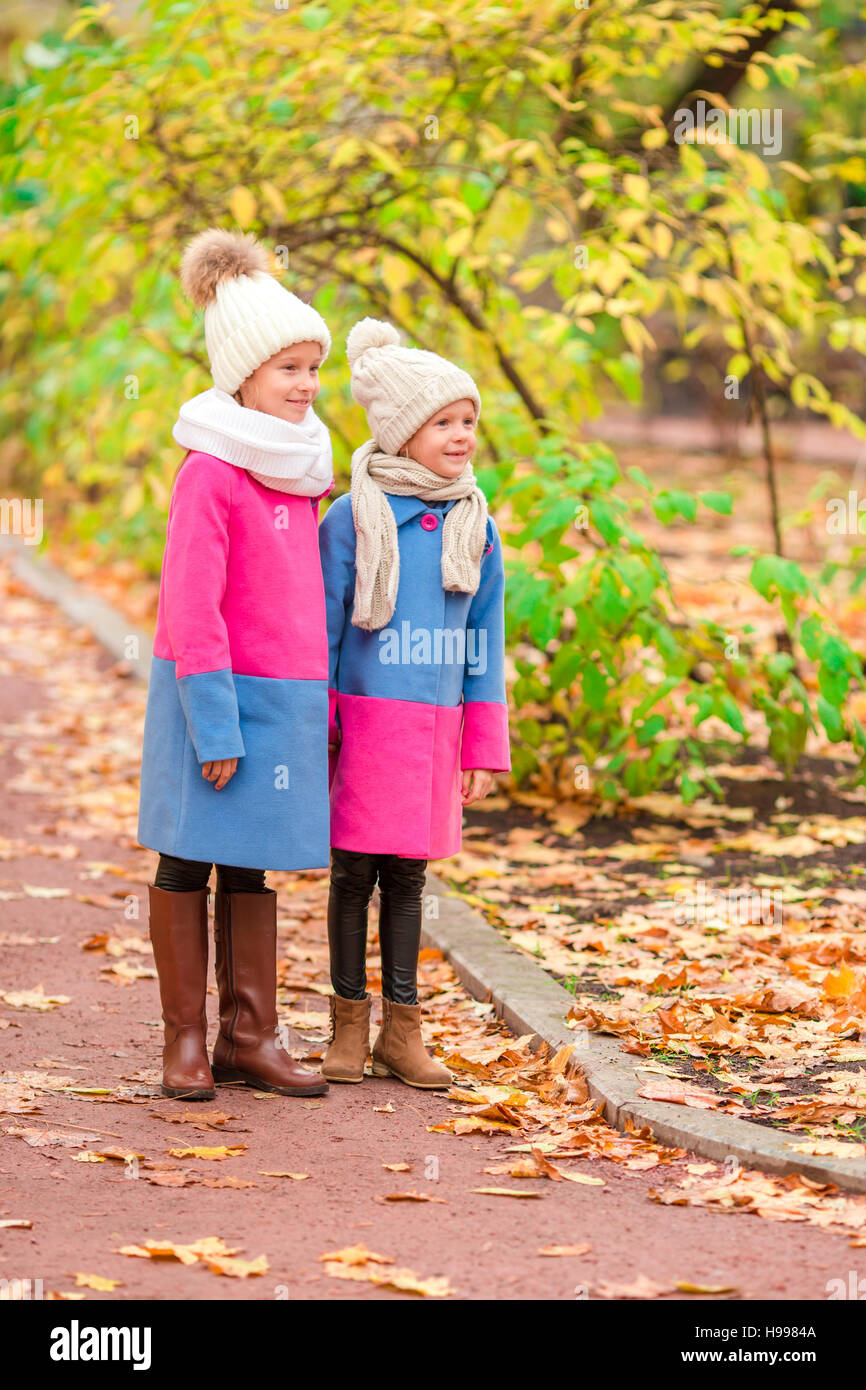 Cute little girls in colorful coats in beautiful autumn day outdoors ...