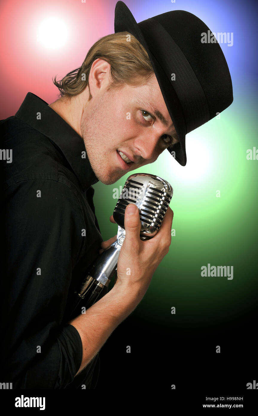 Handsome man singing with a vintage microphone Stock Photo - Alamy