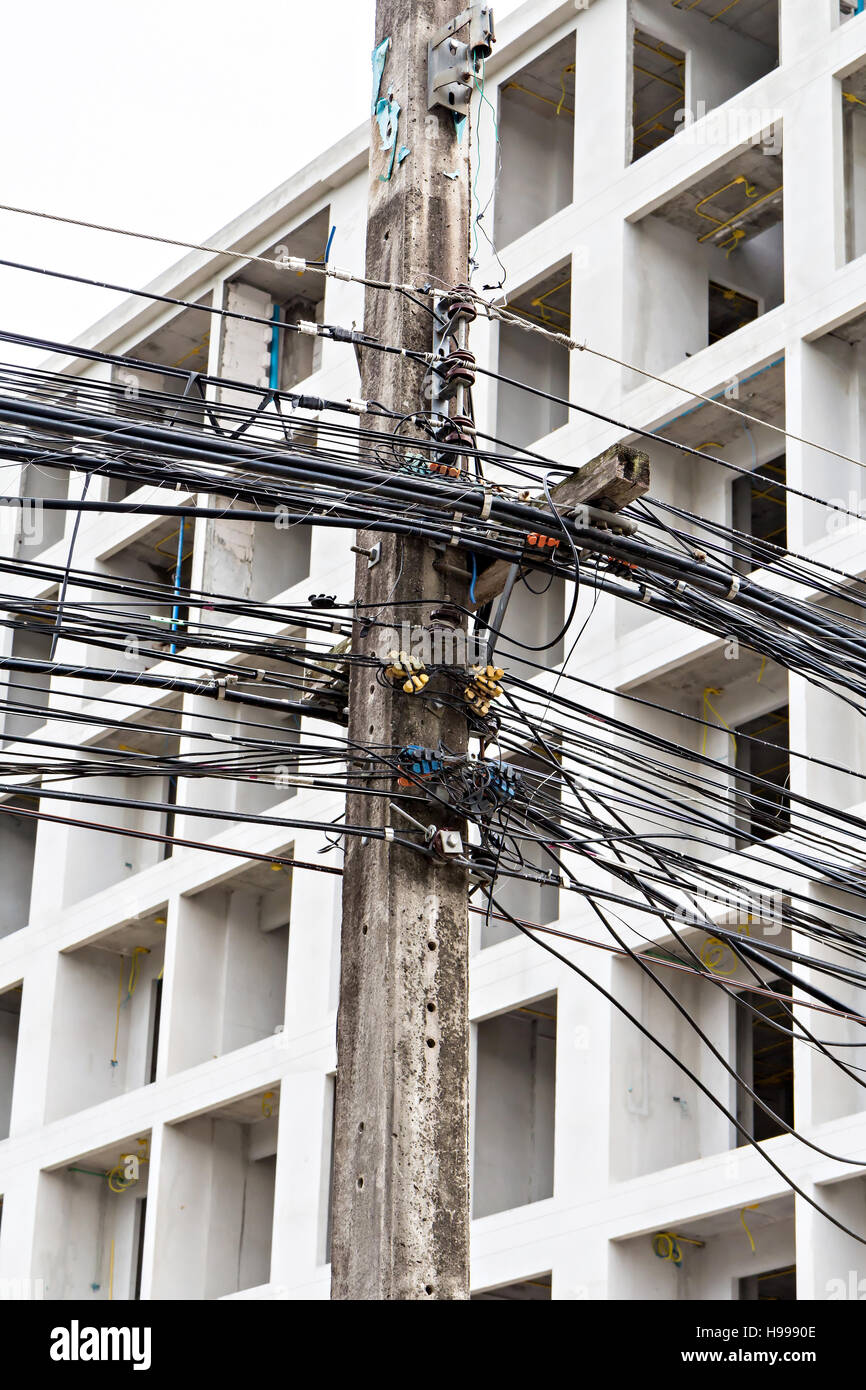 chaotic wires on electricity post Stock Photo - Alamy