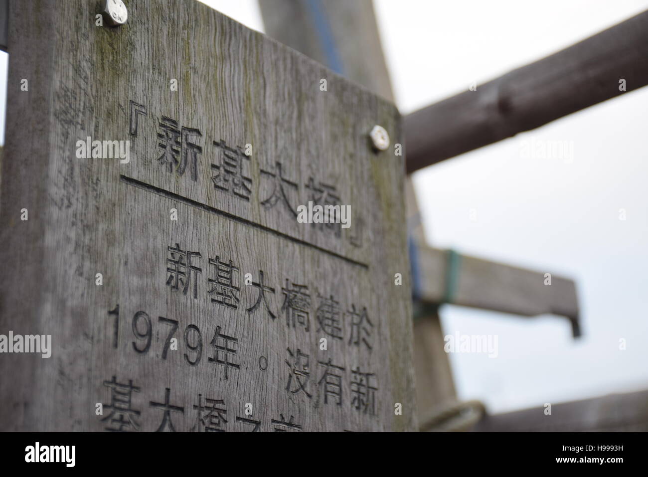 Close-up of a wooden sign with chinese characters indicating a bridge ...