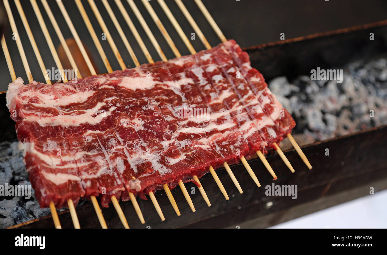 many Red raw meat while cooking on the brazier in a street stall Stock ...