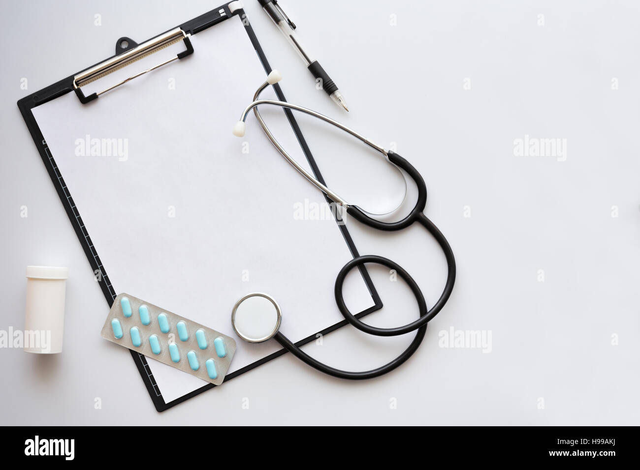 An empty medical file with stethoscope and pen on top of it,next to ...