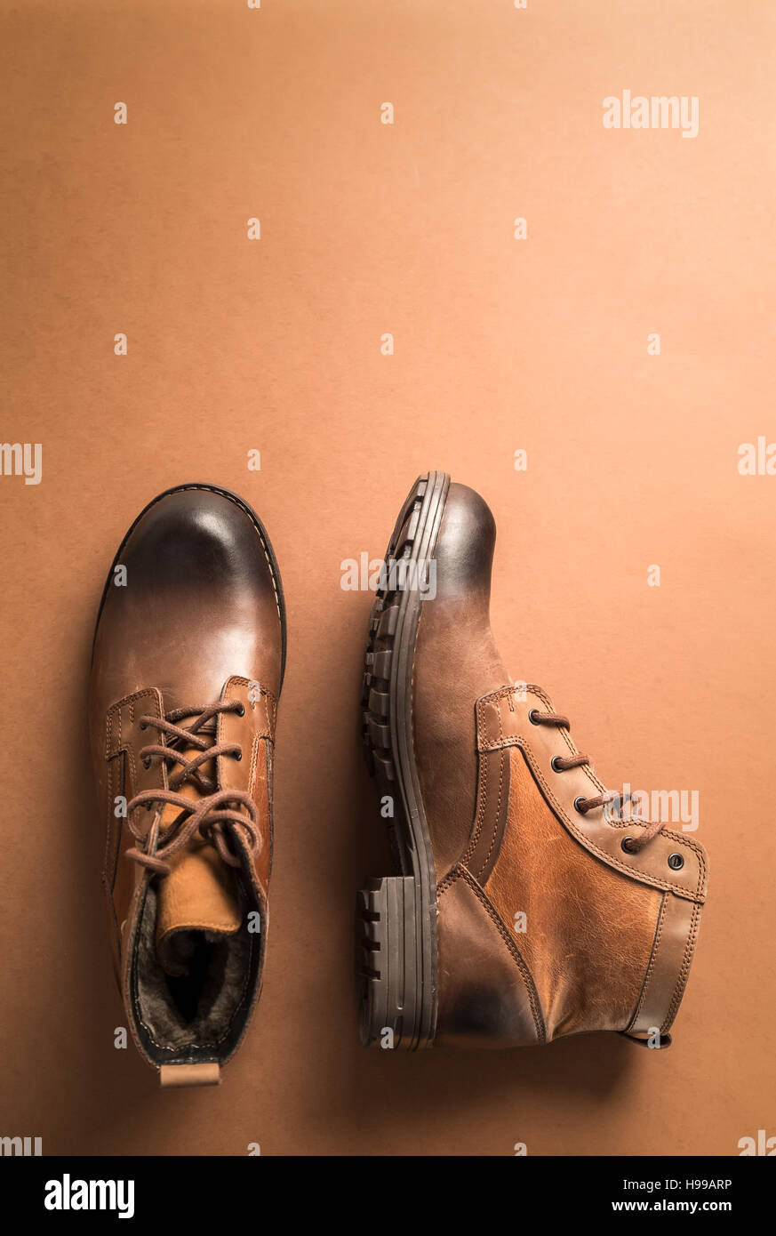 Brown leather boots over brown background,above view with copy space ...