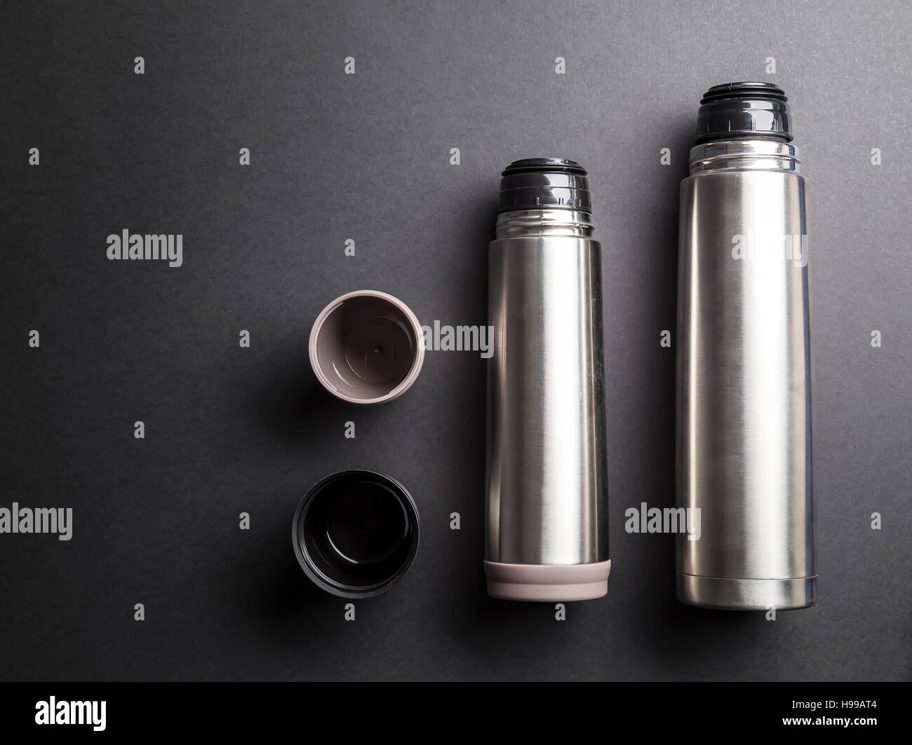 Thermoses organized over black background with copy space for text or ...