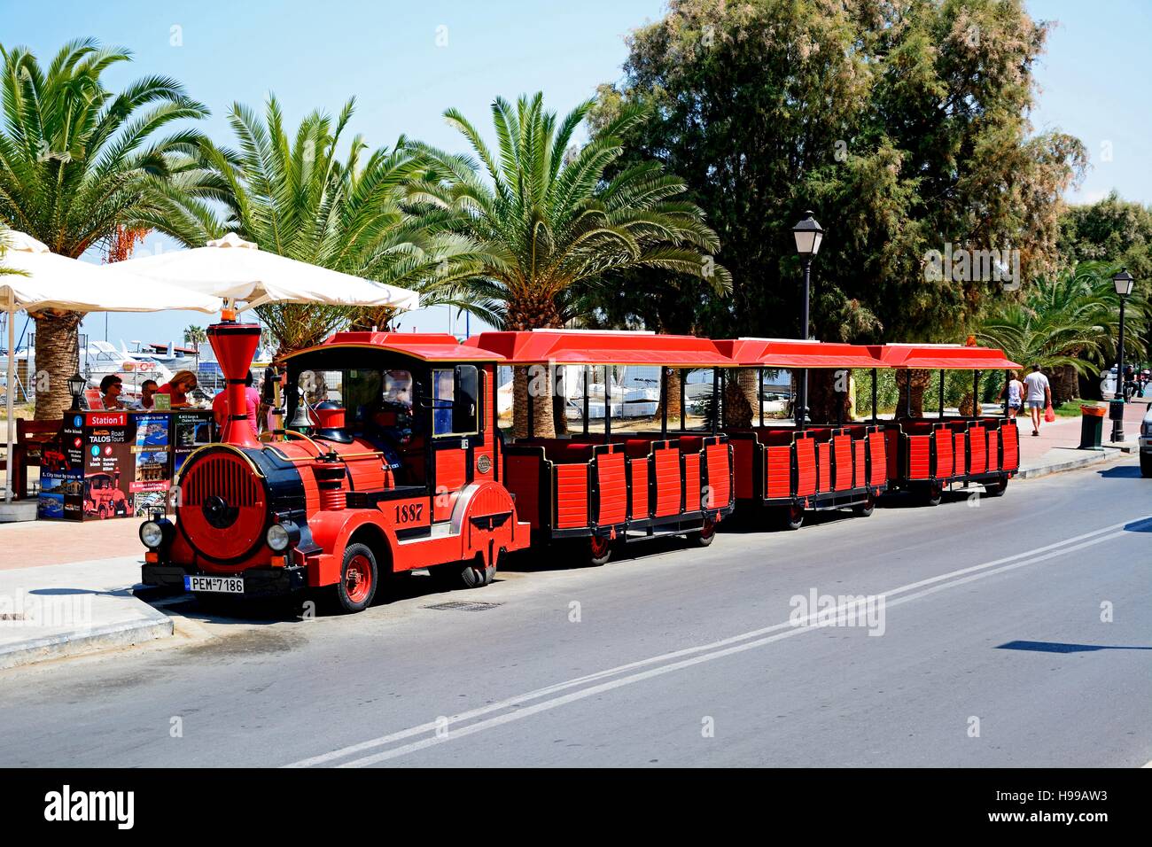 Tourists aboard a red land train along the promenade, Rethymno, Crete ...