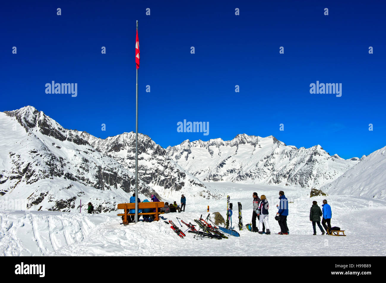 Skiers at the viewpoint Moosfluh in the skiing area Aletsch Arena ...