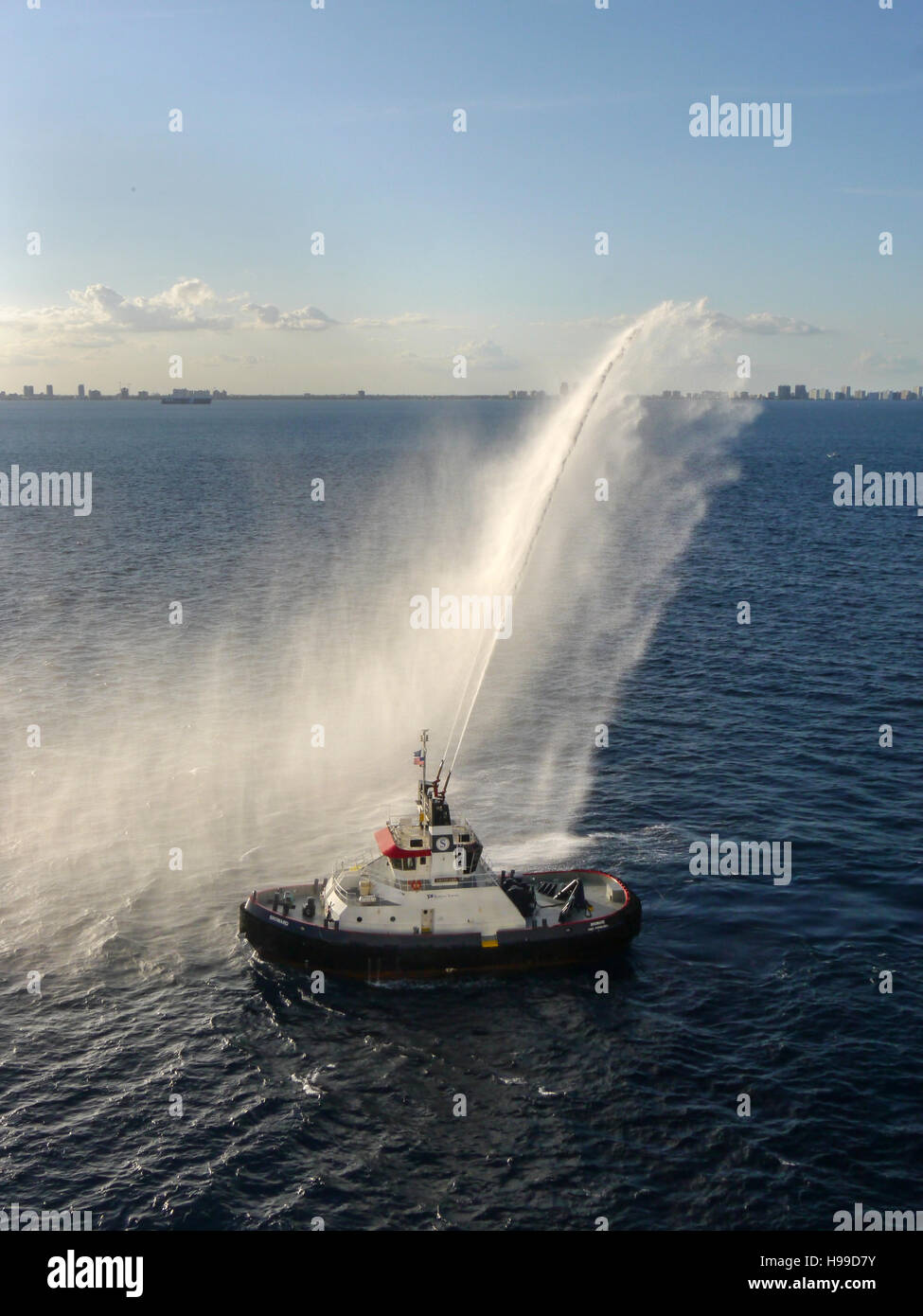 A pilot boat doing a water salute for the arrival of a new cruise ship ...