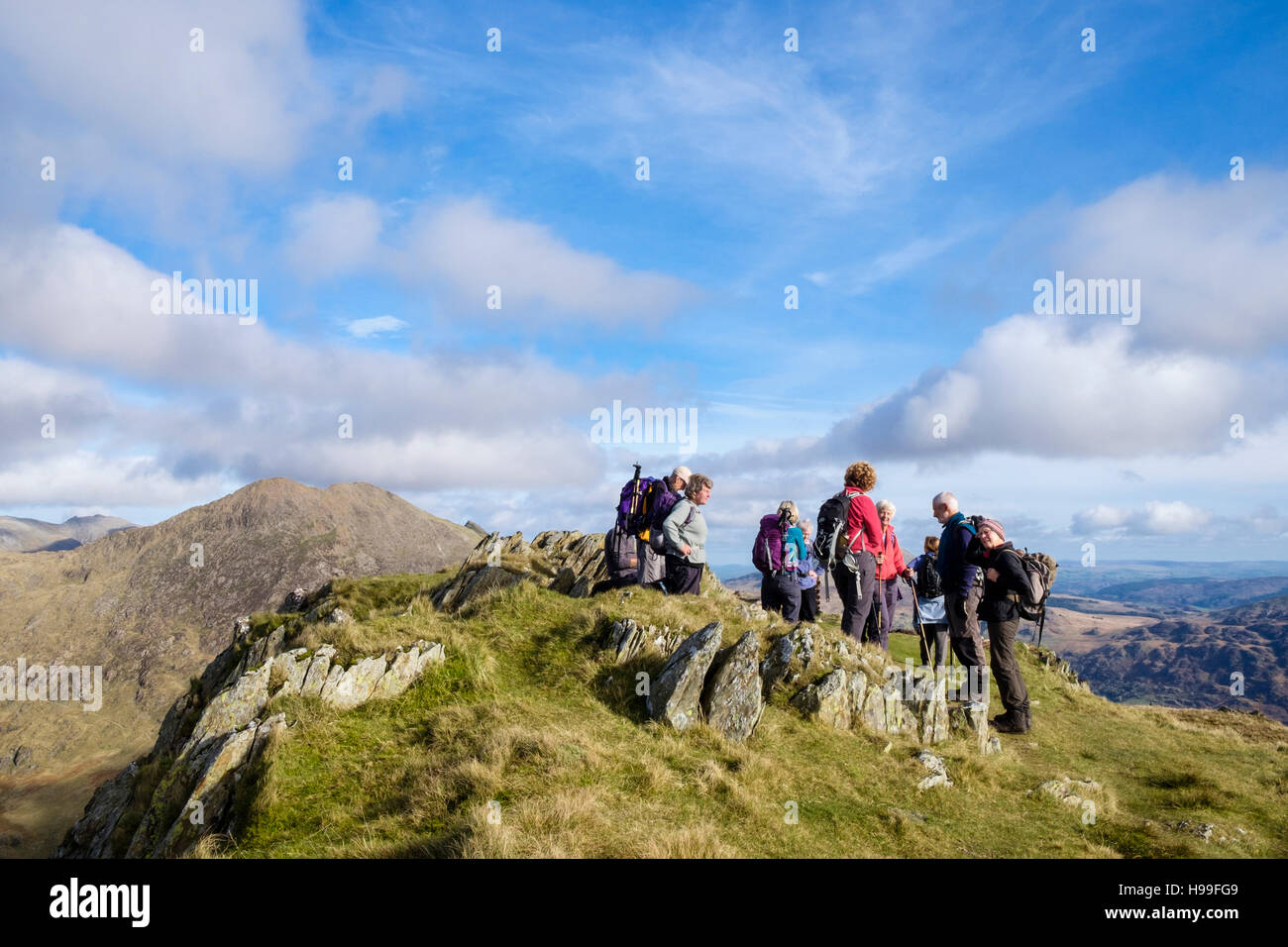 Group of hikers on Yr Aran summit in mountains of Snowdonia National ...