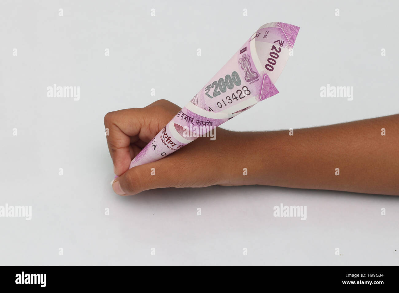 Child's hand hold 2000 rupee note just like a pen. New Indian currency ...