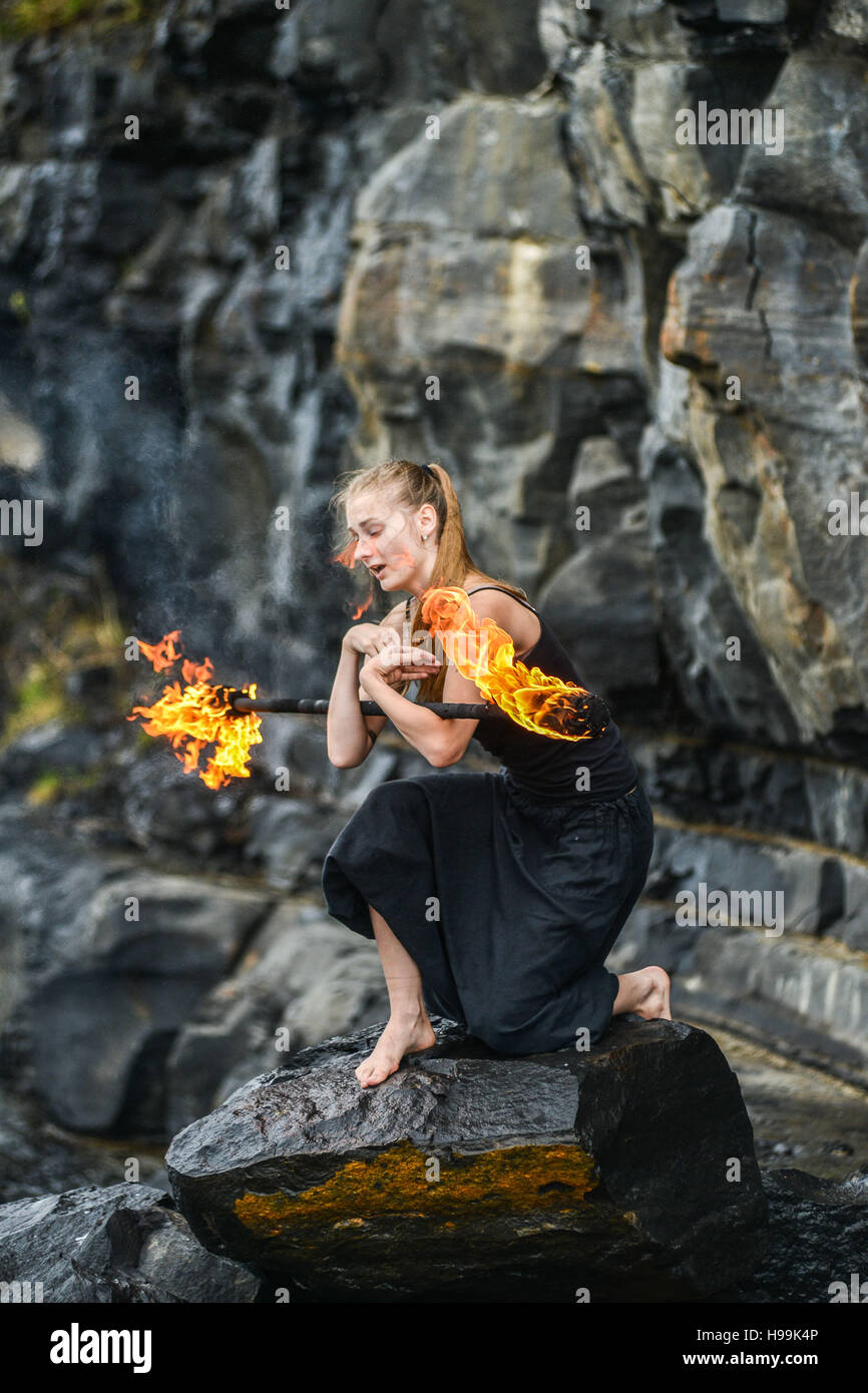 Girl in a black suit with flaming torches Stock Photo - Alamy