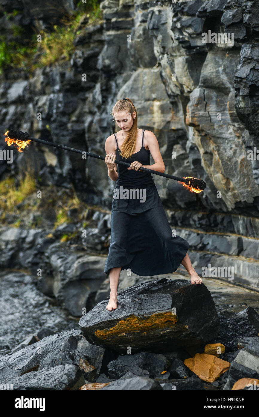 Girl in a black suit with flaming torches Stock Photo - Alamy