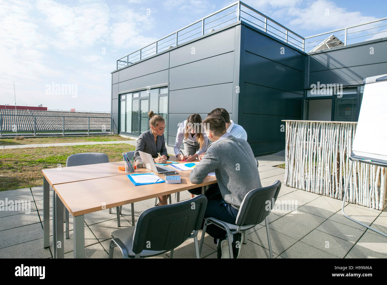 Group of business people working on rooftop terrace Stock Photo - Alamy