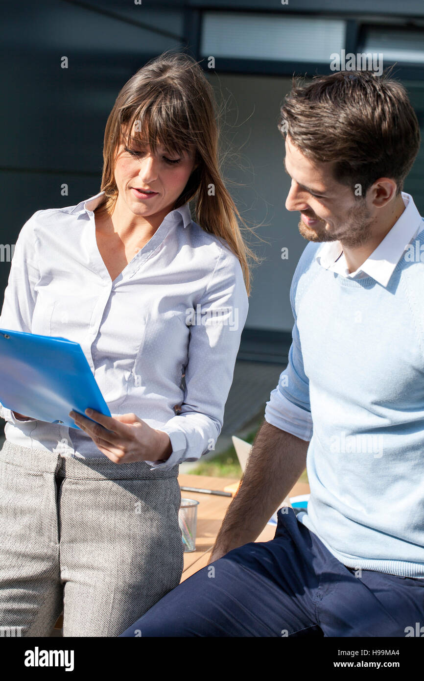 Two business people looking at document Stock Photo - Alamy