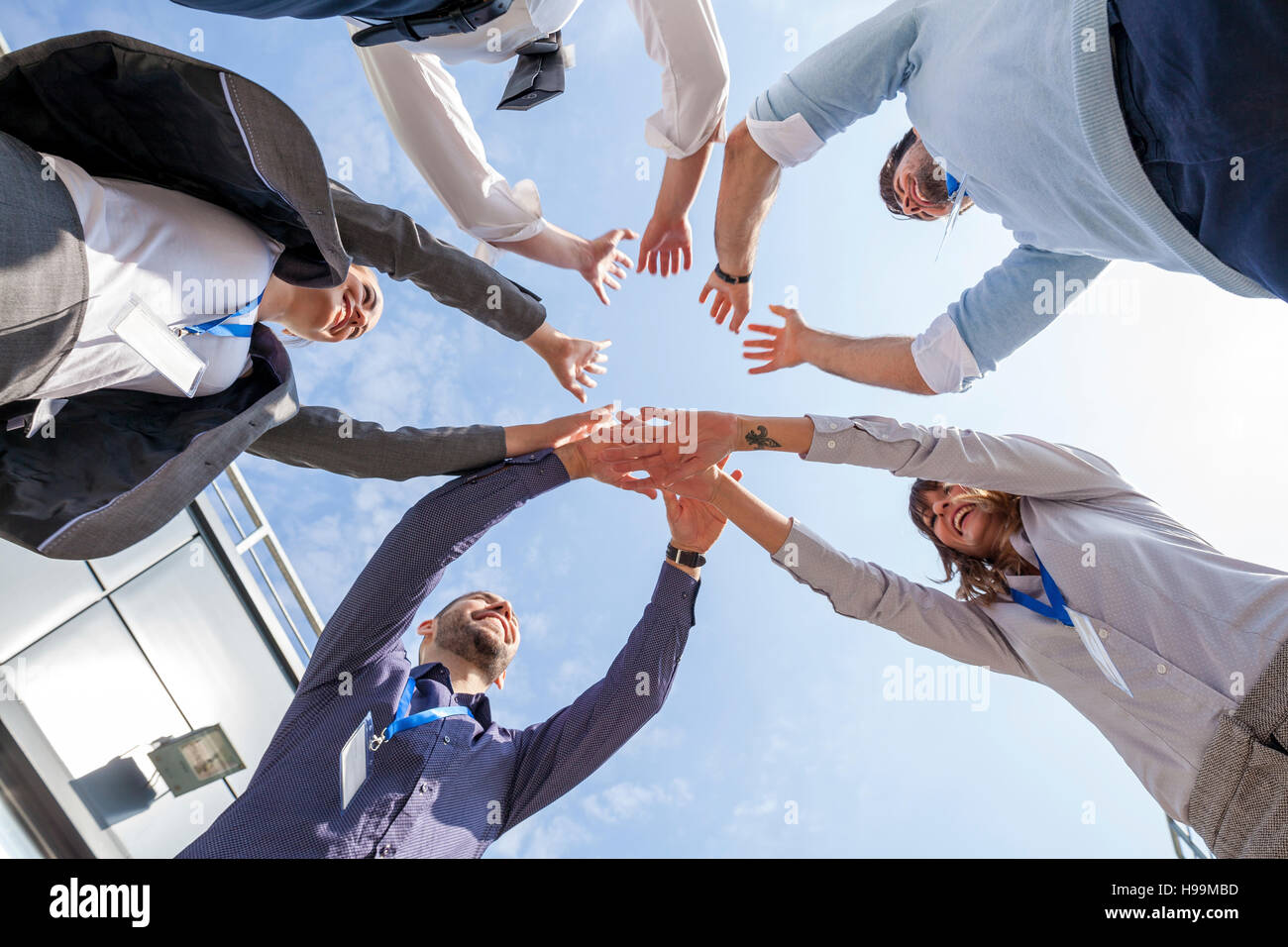 Group of business people in a circle arms raised Stock Photo - Alamy