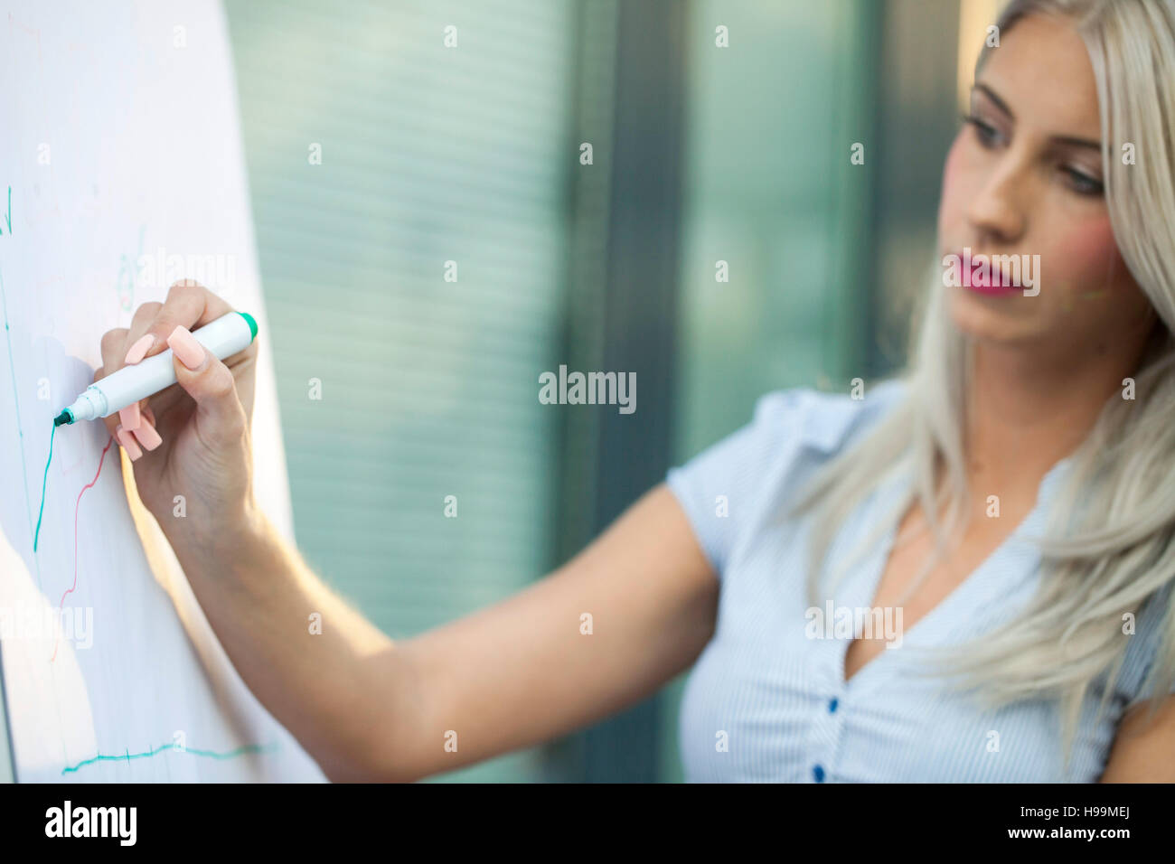 Businesswoman drawing chart on flipchart Stock Photo - Alamy