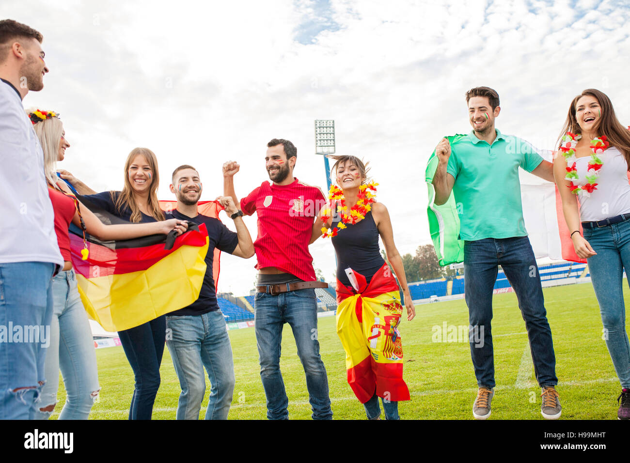 Group of soccer fans celebrating on soccer field Stock Photo - Alamy