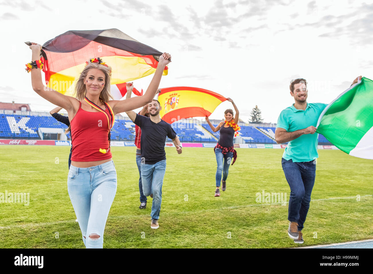 Supporters with different flags running on soccer field Stock Photo - Alamy