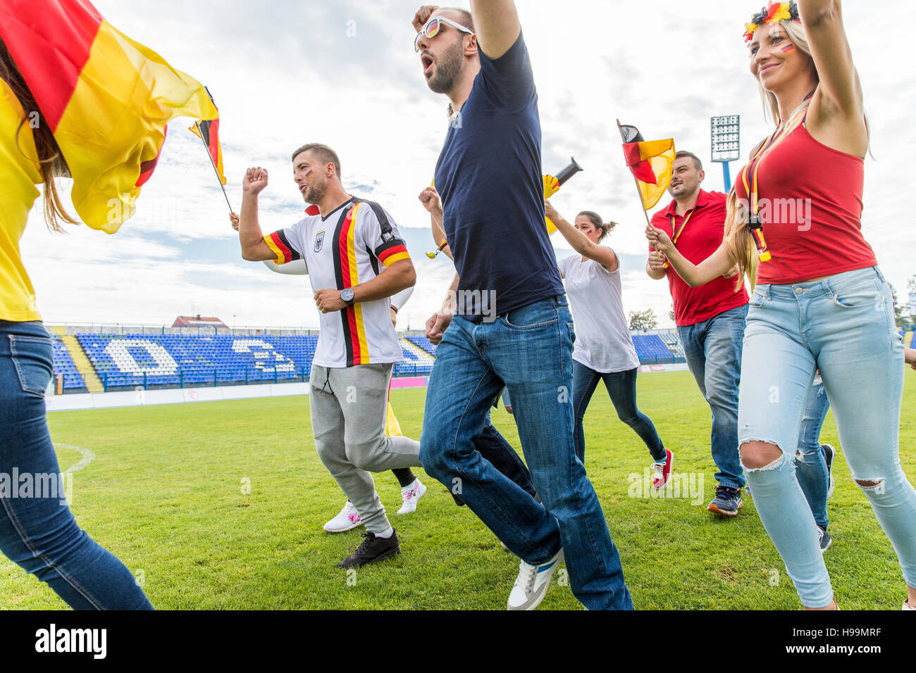 Group of soccer fans running on soccer field Stock Photo - Alamy