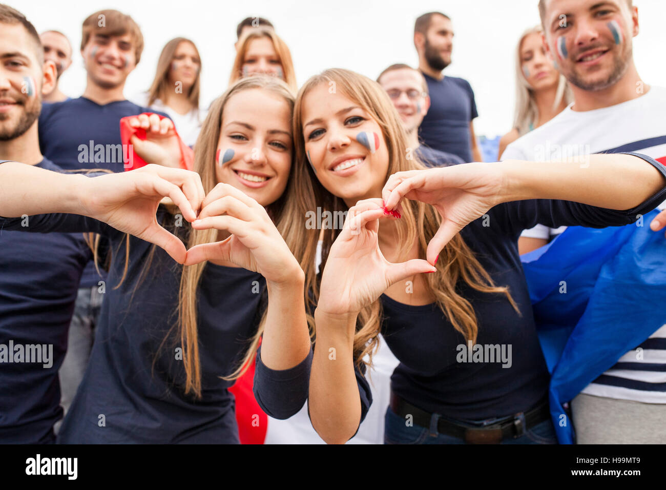 Female soccer fans forming heart with hands Stock Photo - Alamy