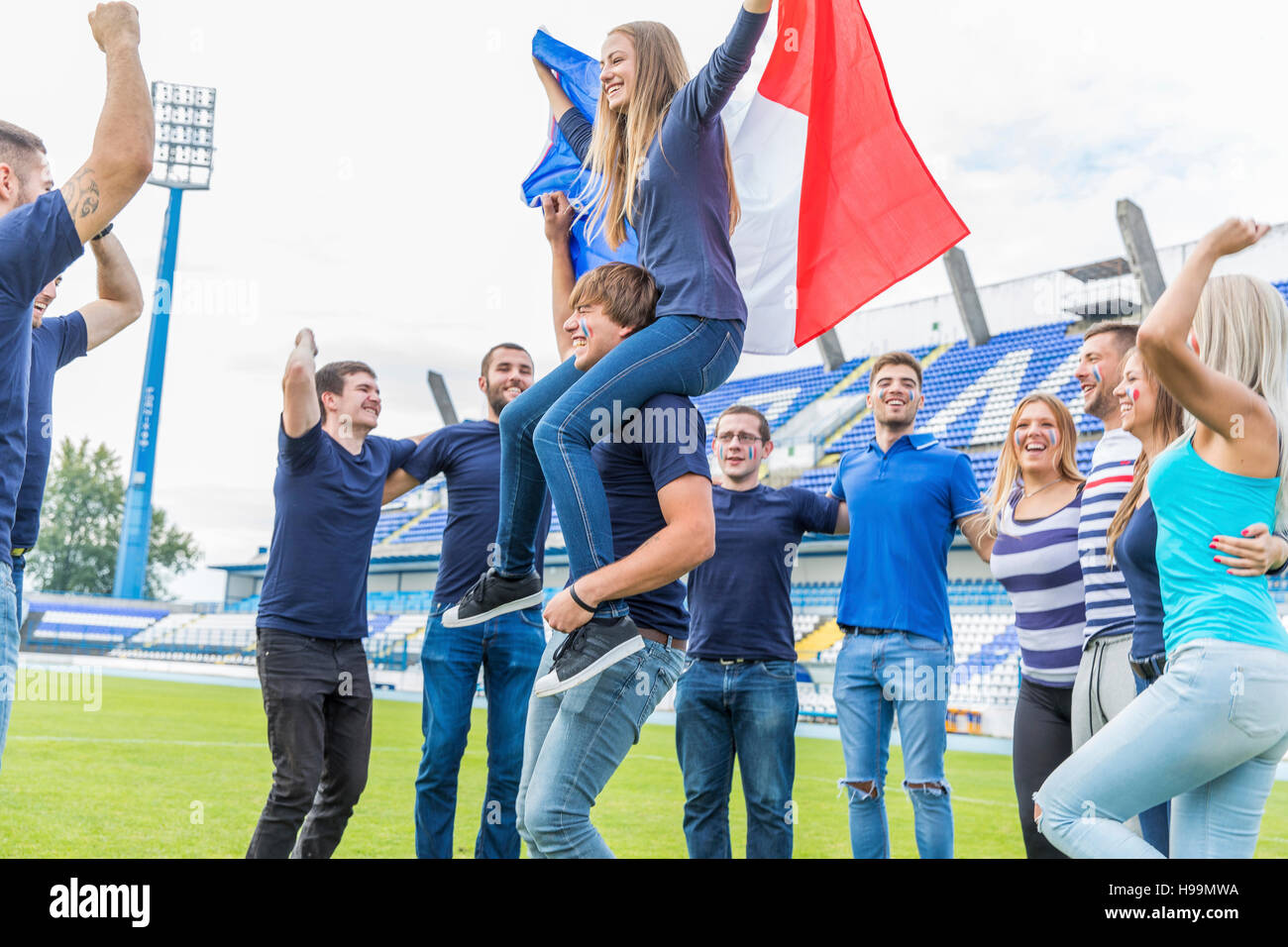 Group of soccer fans celebrating on soccer field Stock Photo - Alamy