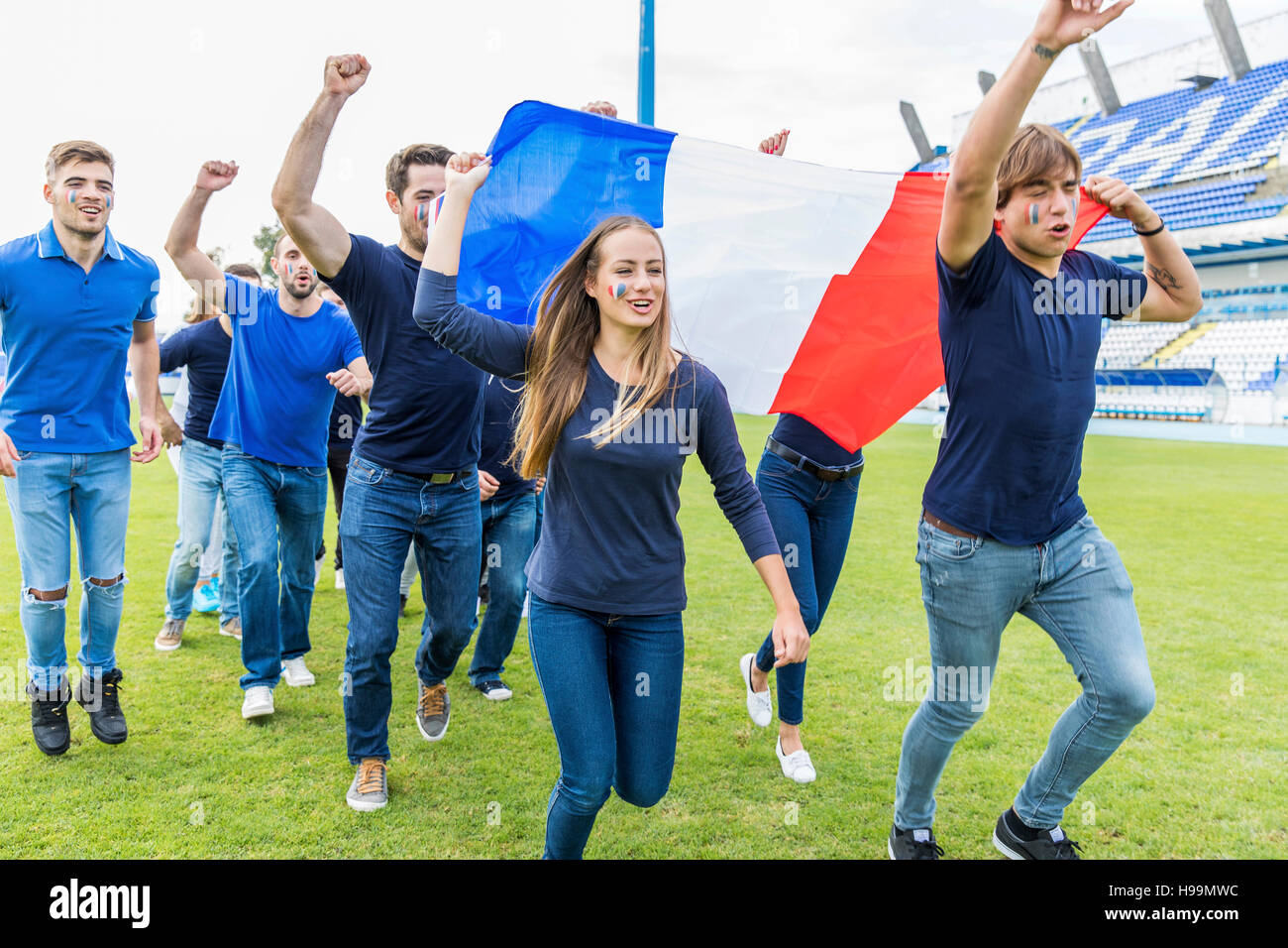 Group of soccer fans celebrating on soccer field Stock Photo - Alamy