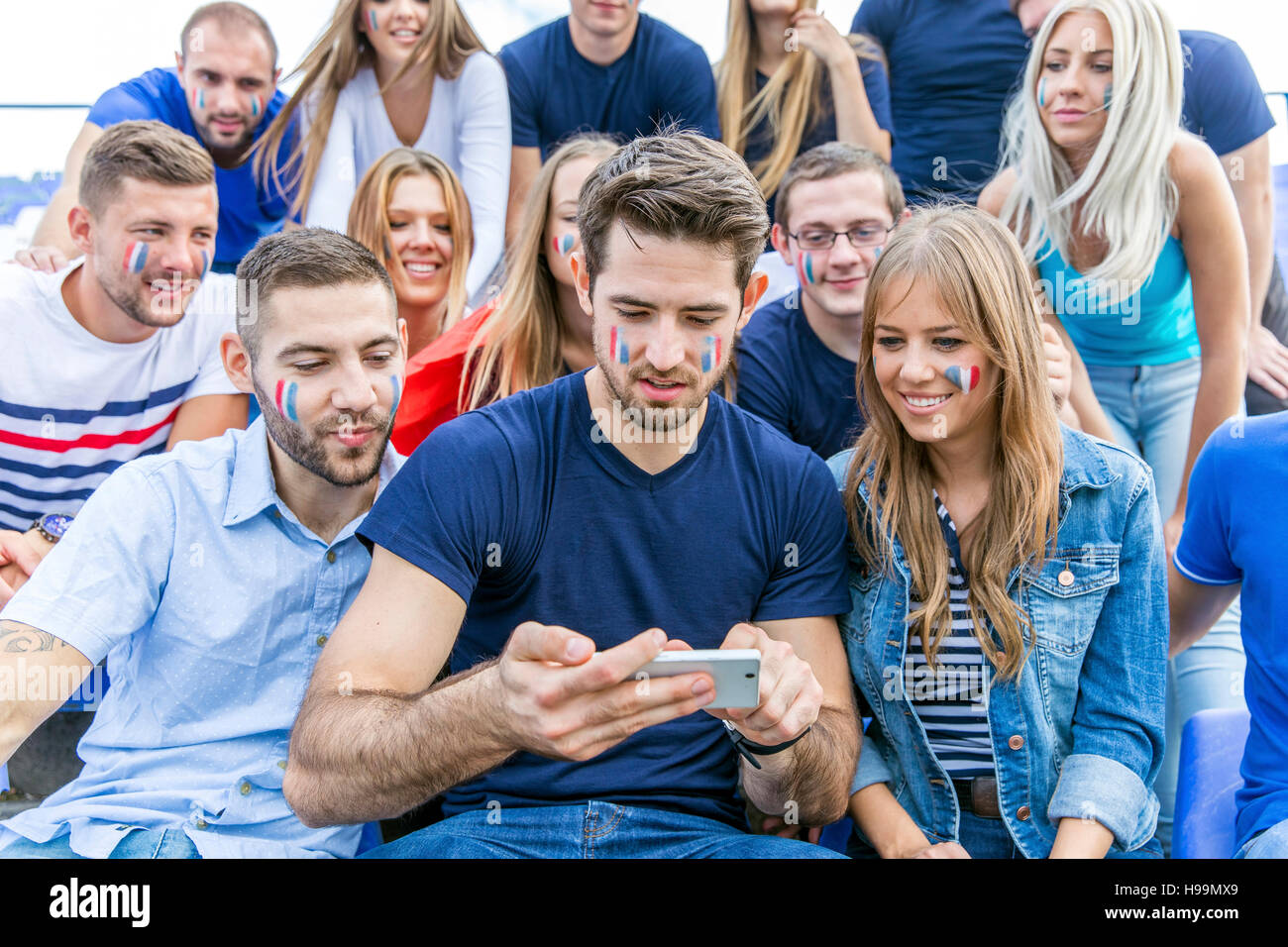 Group of soccer fans text messaging Stock Photo - Alamy