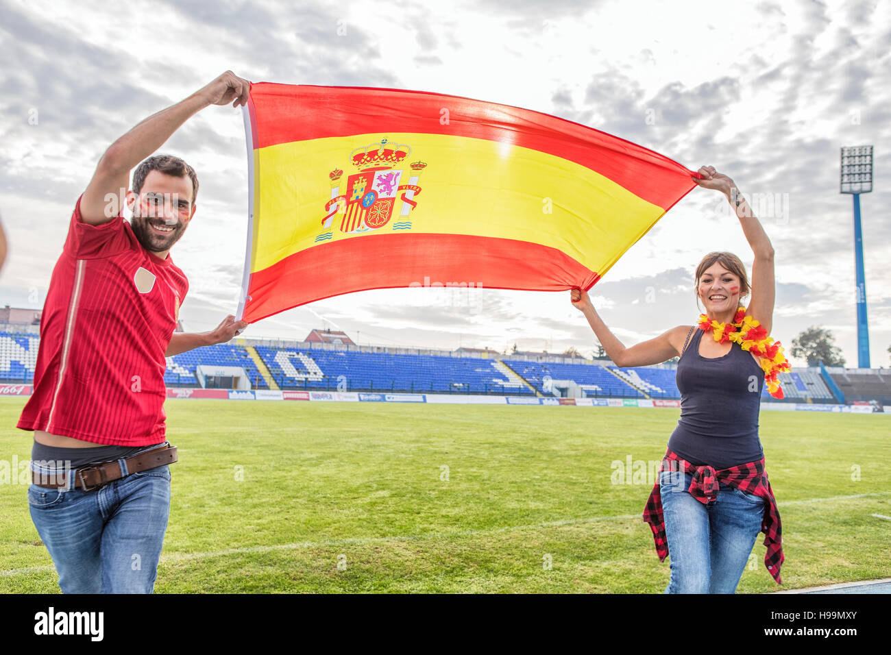 Young couple with face paint waving Spanish flag Stock Photo - Alamy